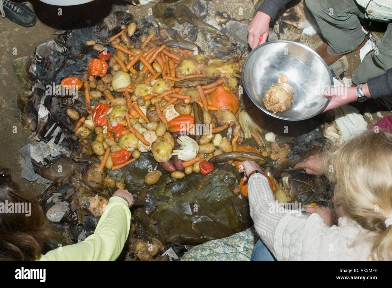 opening the pit oven at a curanto cooking in a pit oven vegetables and ...