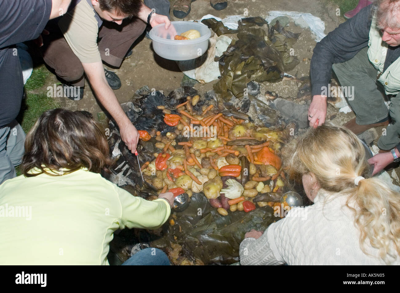 opening the pit oven at a curanto cooking in a pit oven vegetables and ...