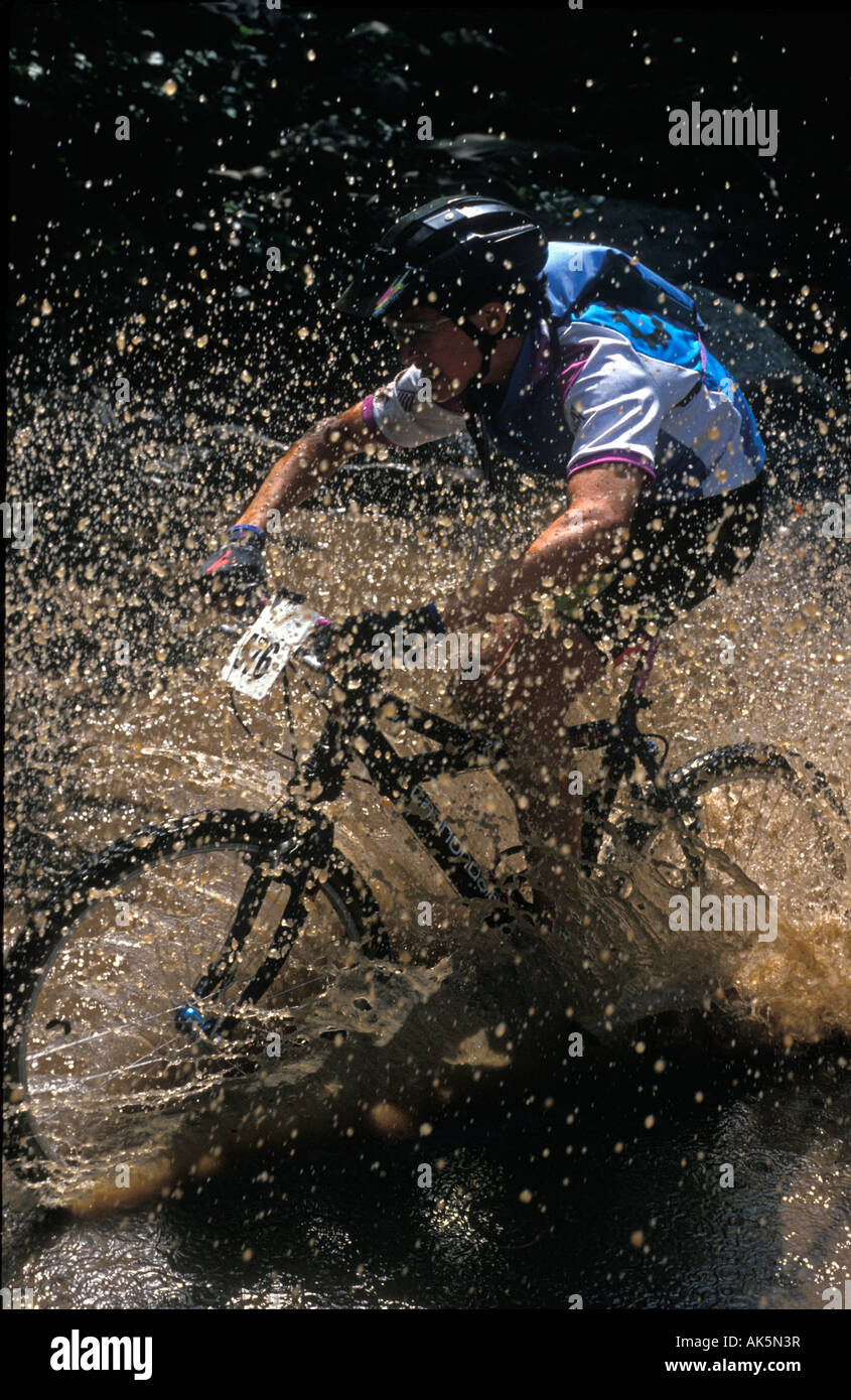 Mountain biker in a competition going through a deep puddle somewhere ...
