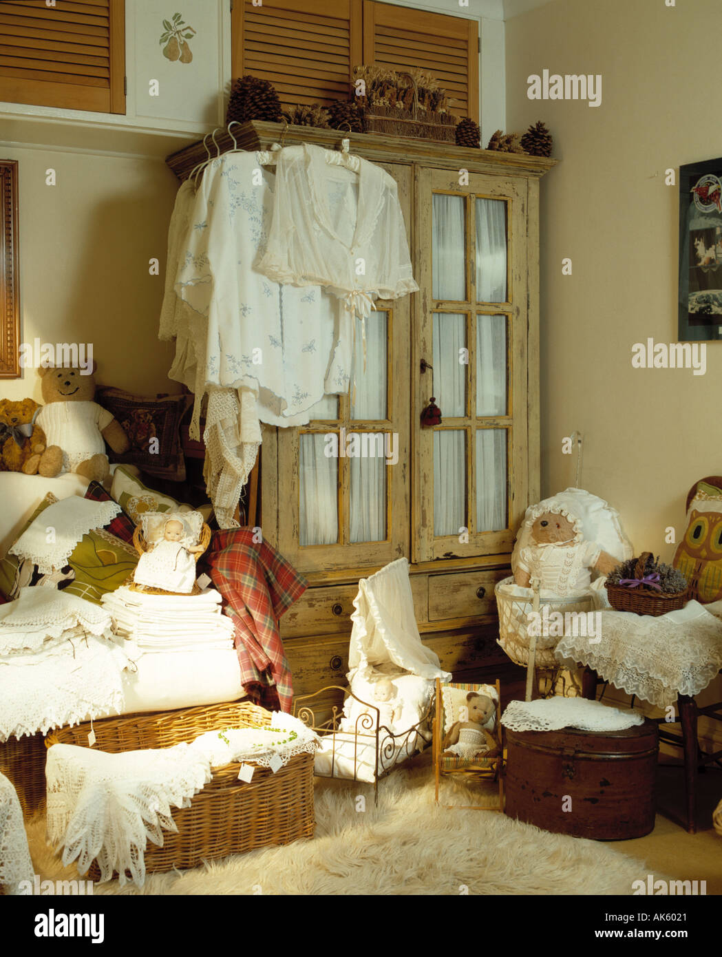 White vintage clothes hanging on pine cupboard with glazed doors in ...