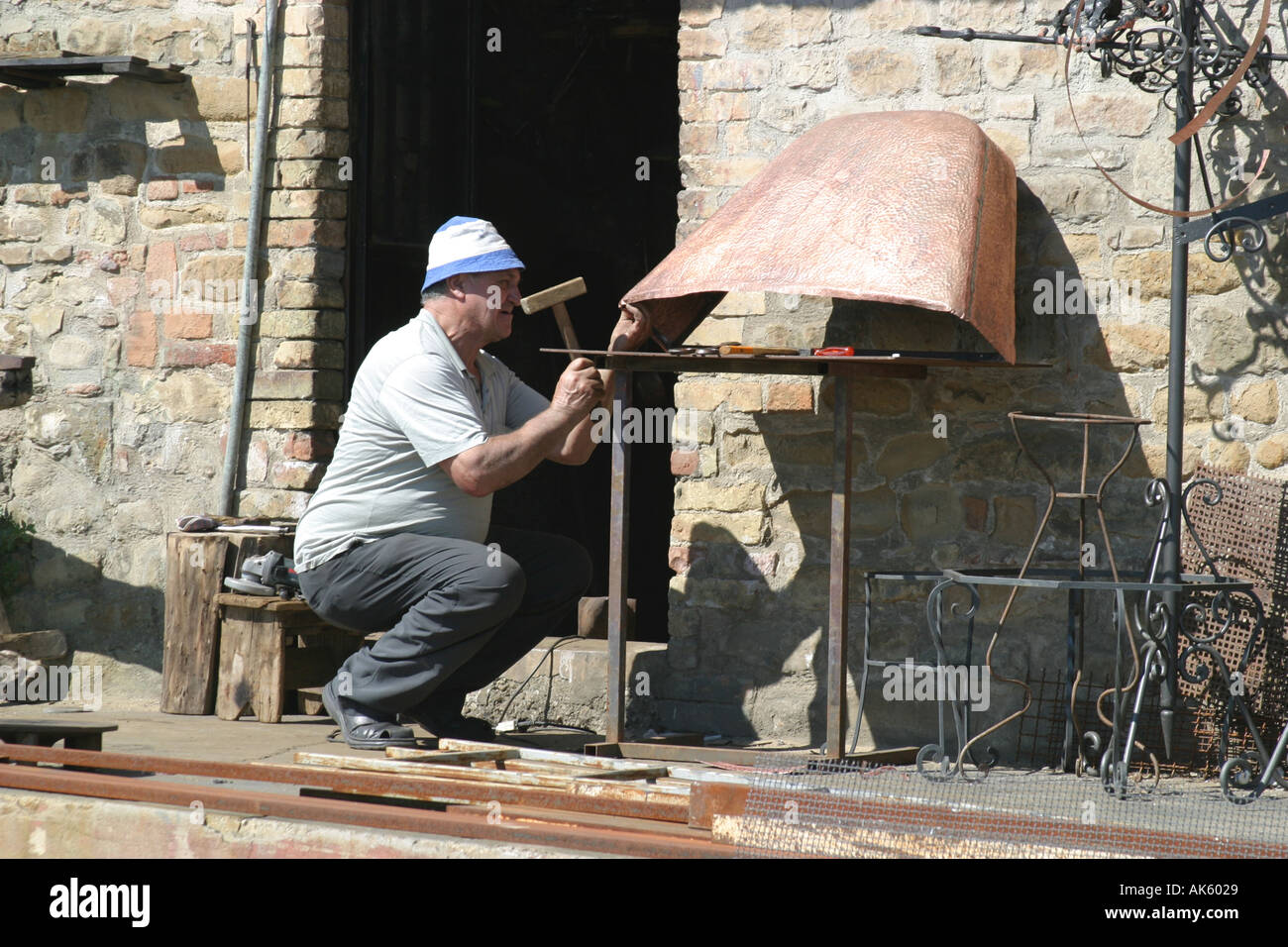Metal worker beating a panel in Le Marche ,Italy Stock Photo - Alamy