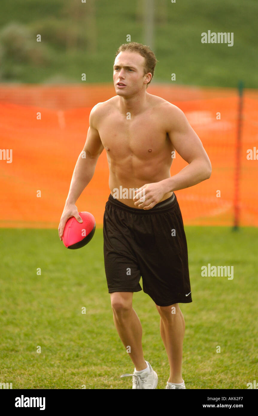 A man playing touch American football in a park and celebrating a ...