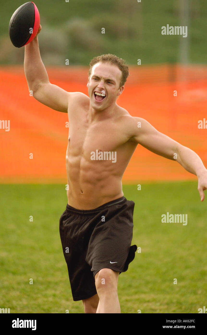 A man playing touch American football in a park and celebrating a ...