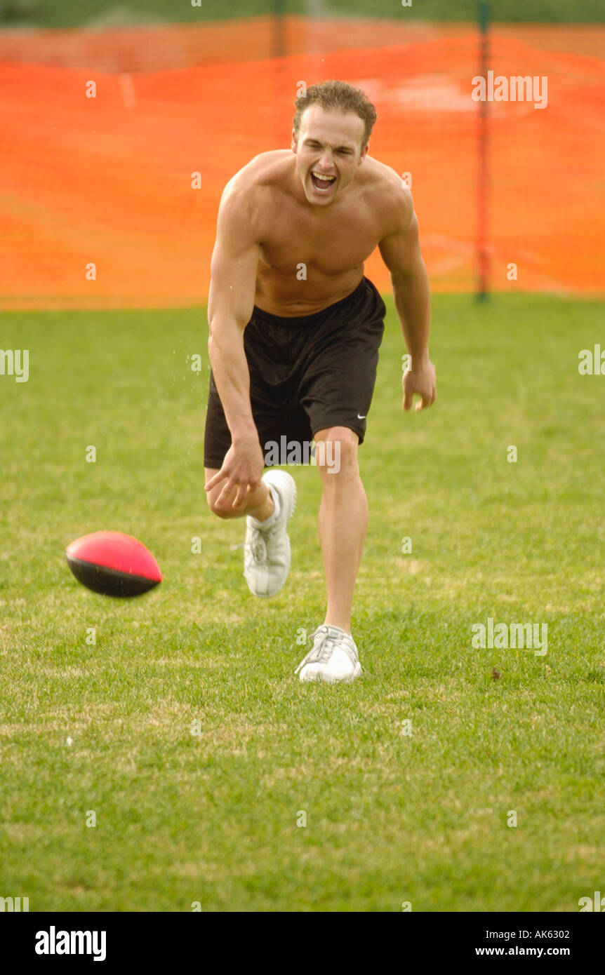 A man playing touch American football in a park and celebrating a ...