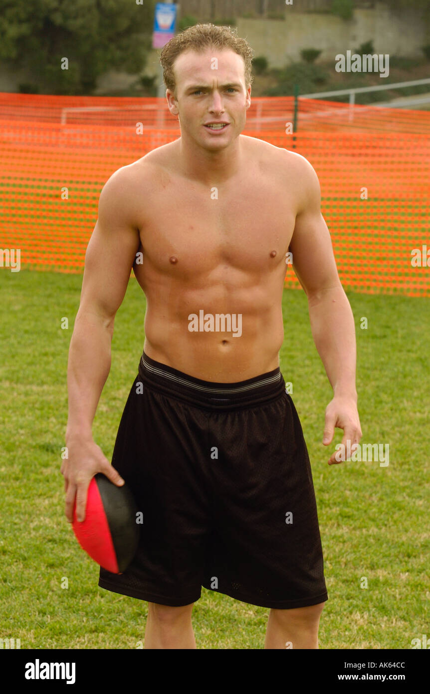A man playing touch American football in a park and celebrating a ...