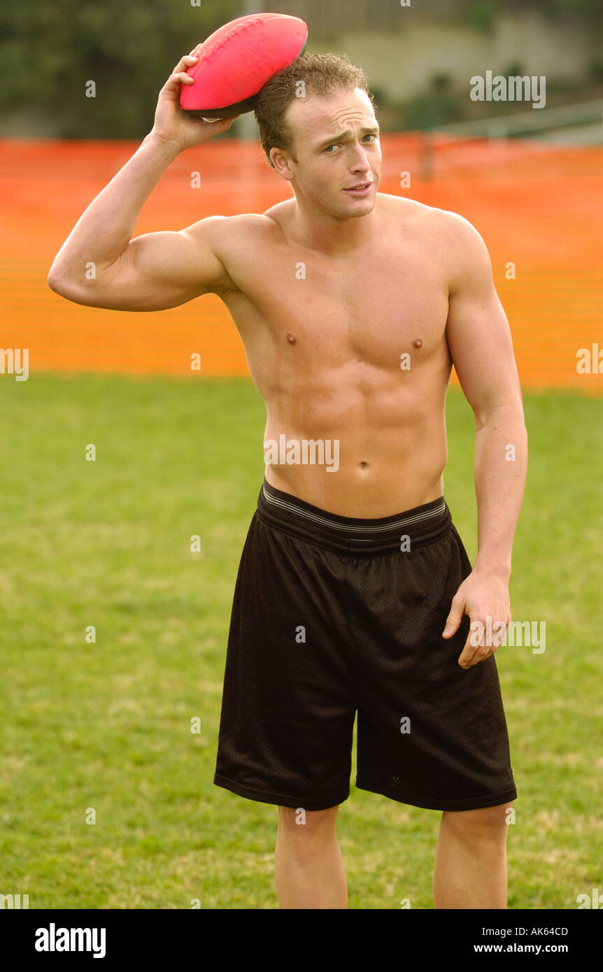 A man playing touch American football in a park and celebrating a ...