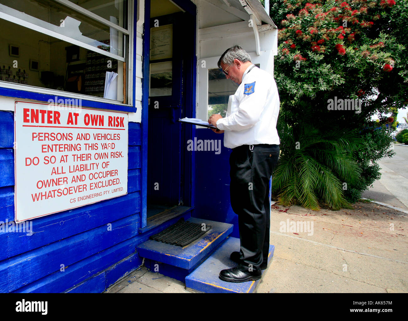 A security guard checks off a vehicle at the entrance to an industrial ...