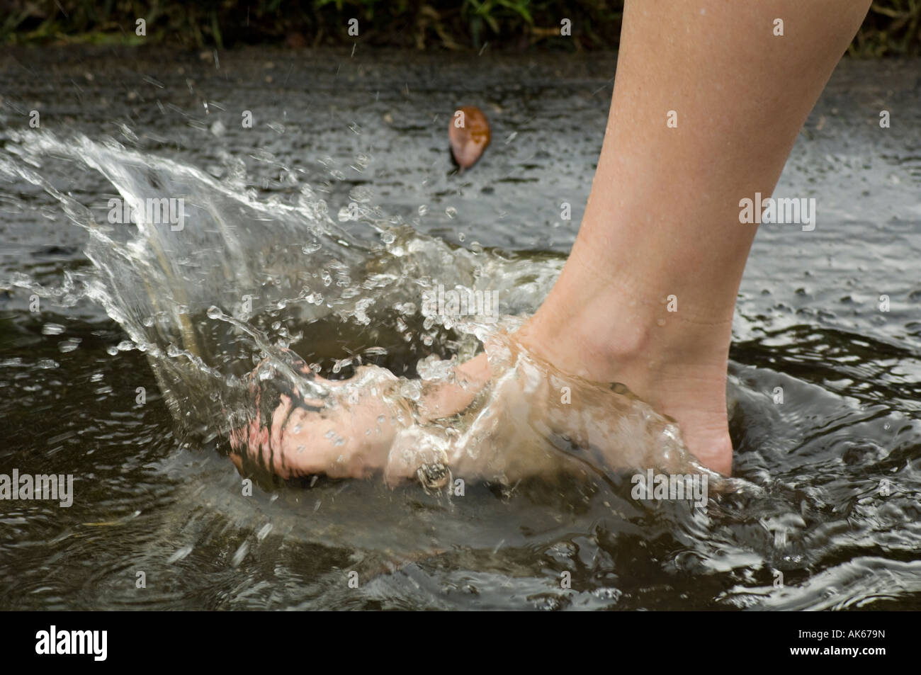 closeup bare foot hitting water puddle Stock Photo - Alamy