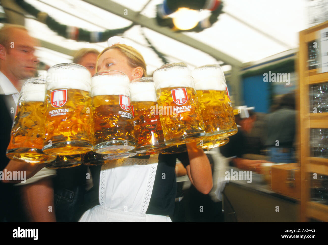 Waitress dressed in dirndl serving Liter glasses of beer in Oktoberfest ...