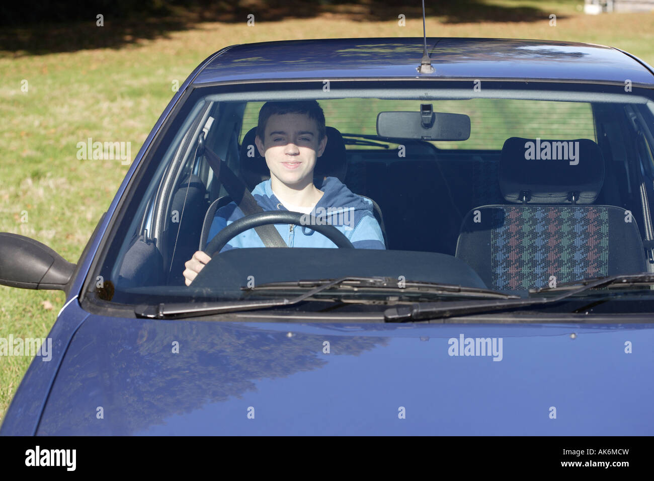 Boy learning to drive his fathers car in a field Stock Photo - Alamy