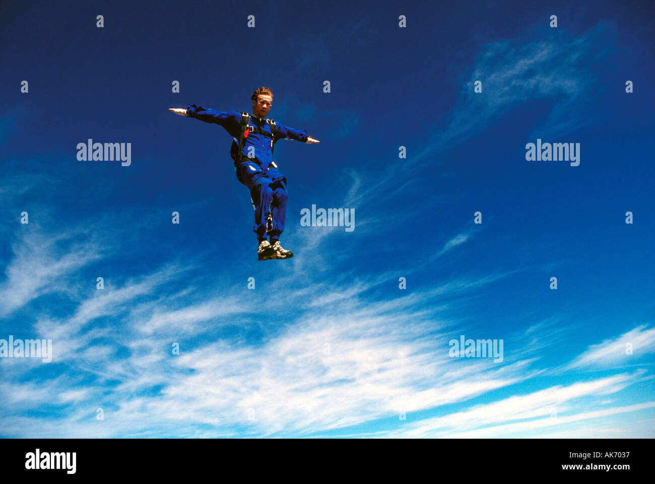 Sky diver flying through the air in a classic upright standing pose ...