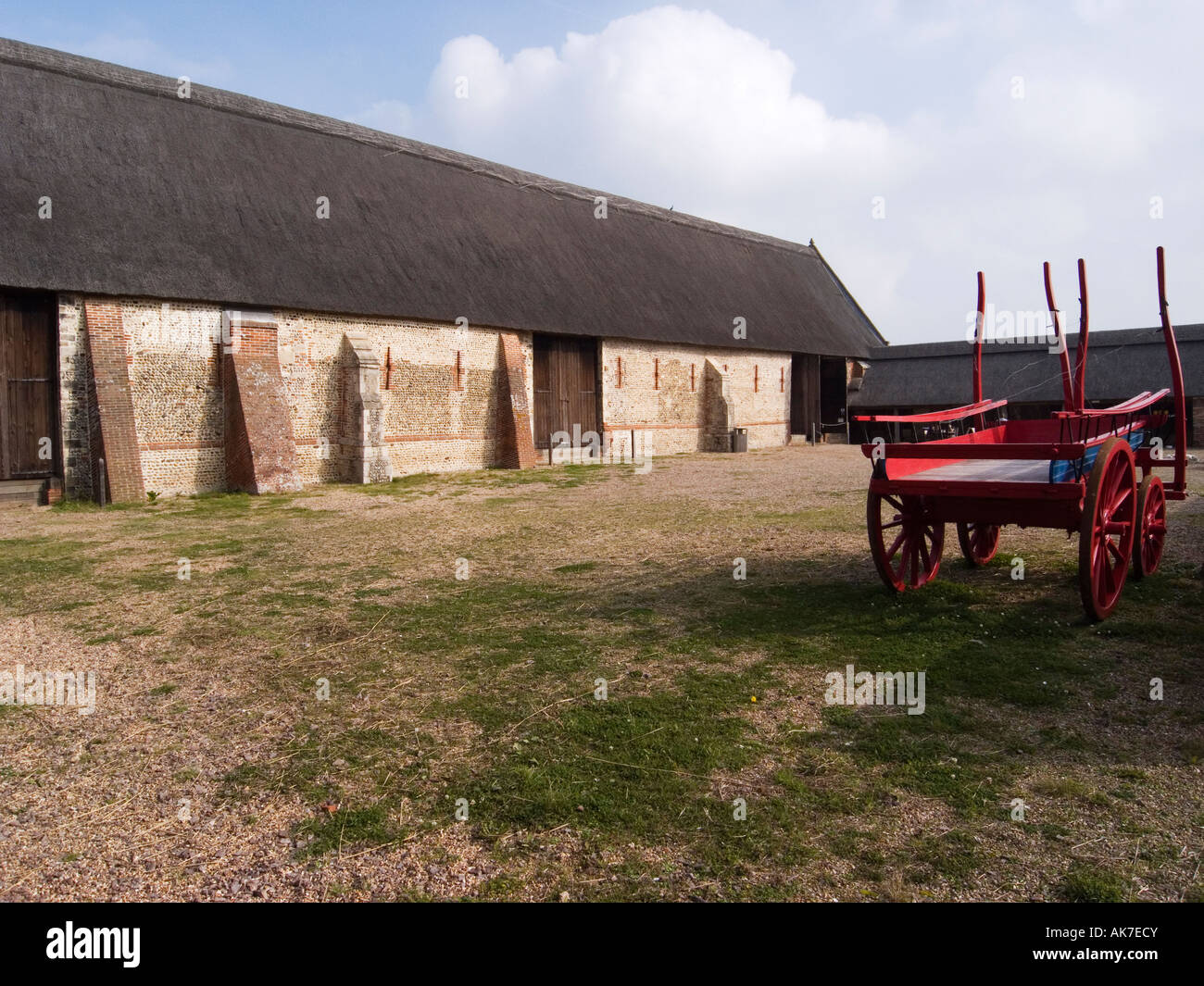 Traditional East Anglian barn with brick and flint walls and thatched ...