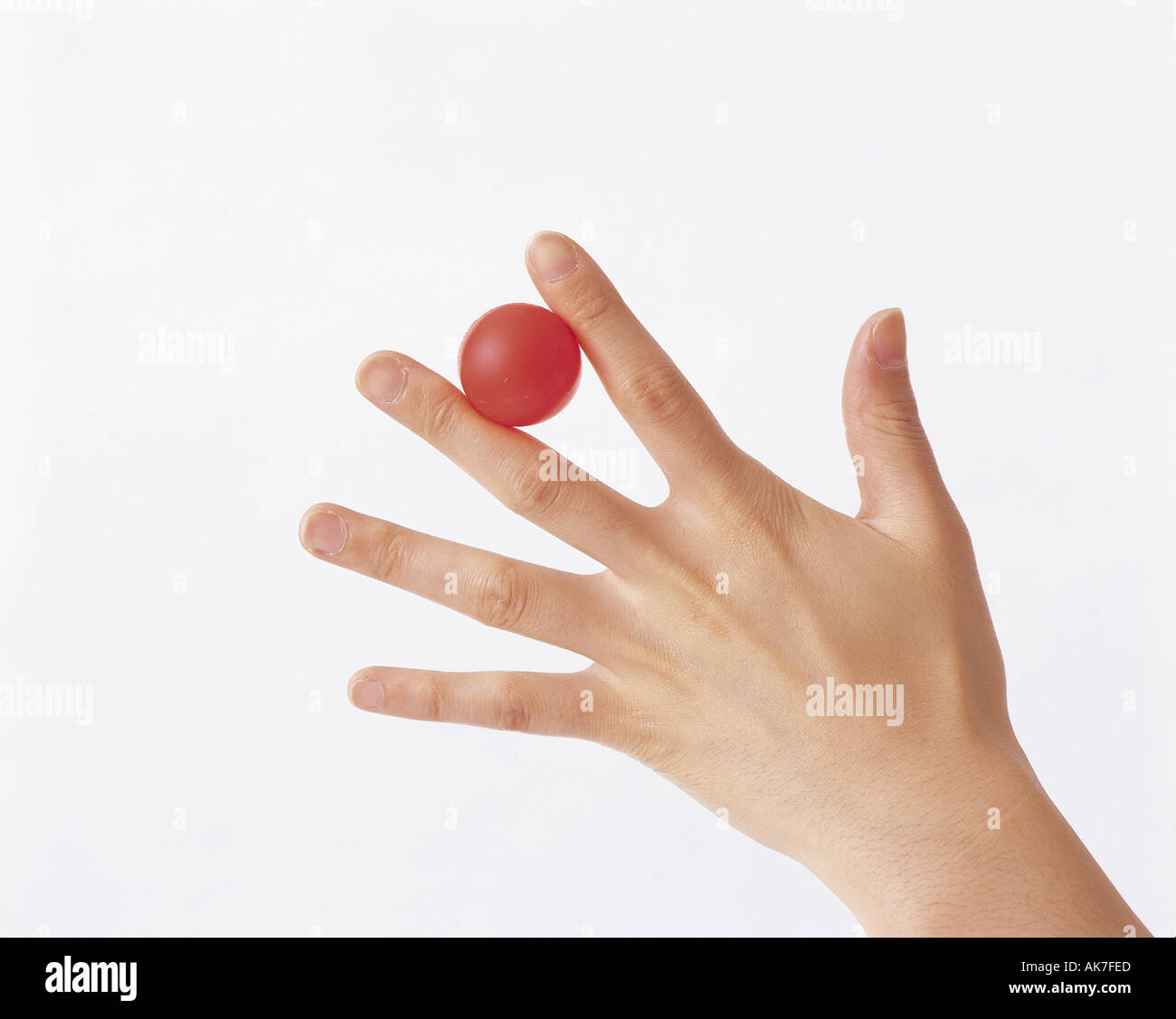 Hand holding red ball Stock Photo - Alamy