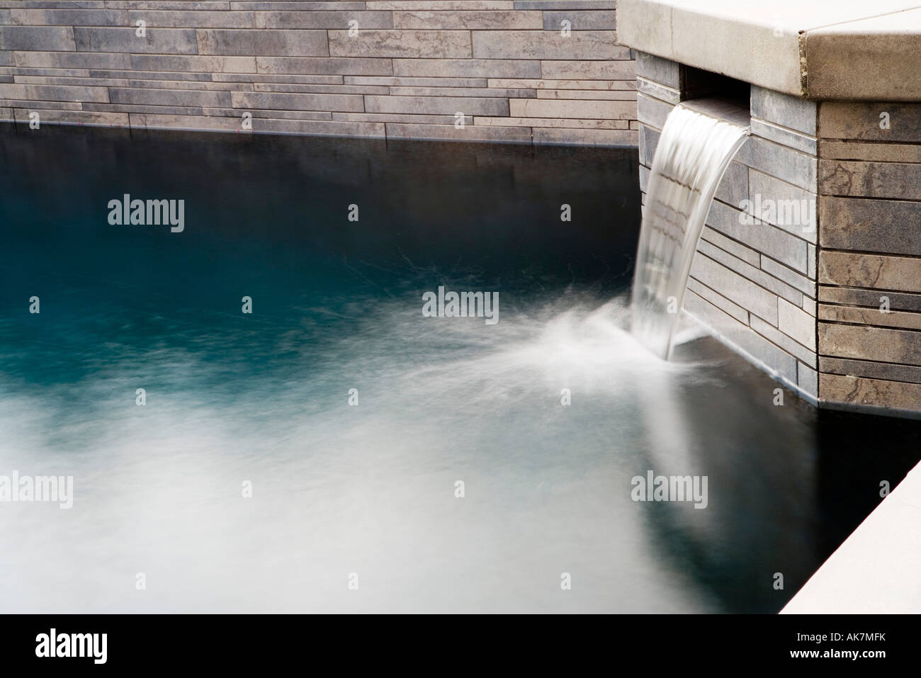 Waterfall from Stone Jacuzzi to Swimming Pool Stock Photo - Alamy