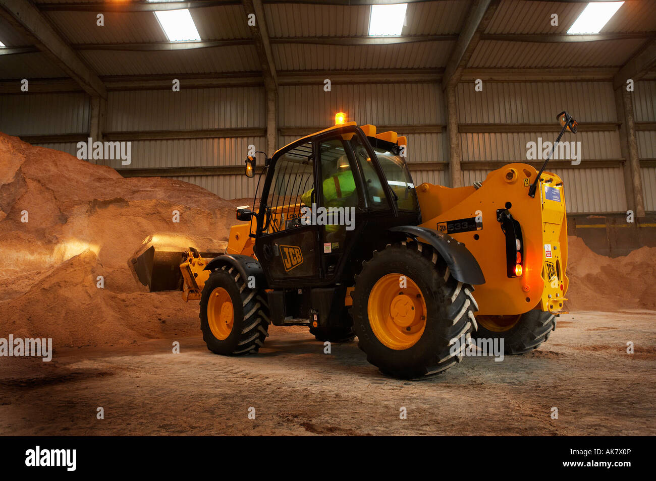 YELLOW JCB MECHANICAL LOADER MOVING ROCK SALT AND GRIT Stock Photo - Alamy