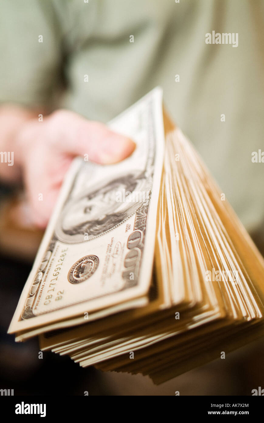 man holding a bundle of dollars Stock Photo - Alamy
