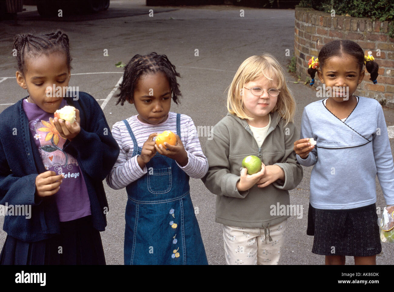 nursery school children eating fruit in the playground Stock Photo - Alamy