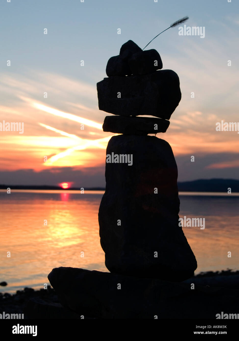 A stack of stones artistically arranged against the sunset, by the ...