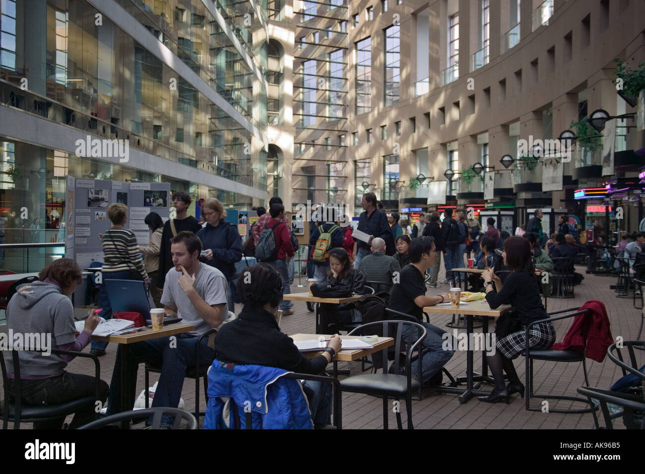 People at cafe tables in interior courtyard at Vancouver Public Library ...