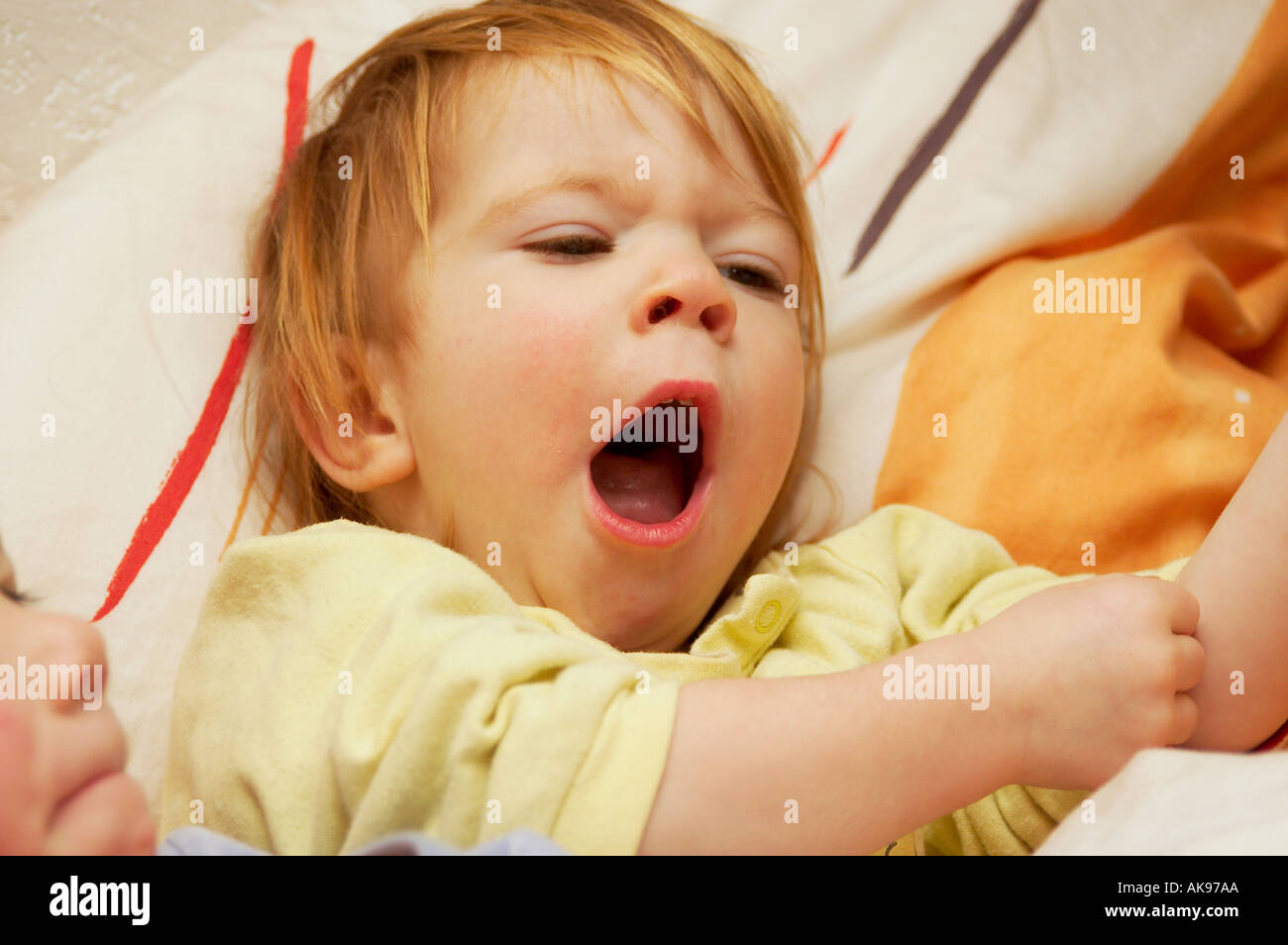 child is tired in the bed yawning has to sleep MR Stock Photo - Alamy