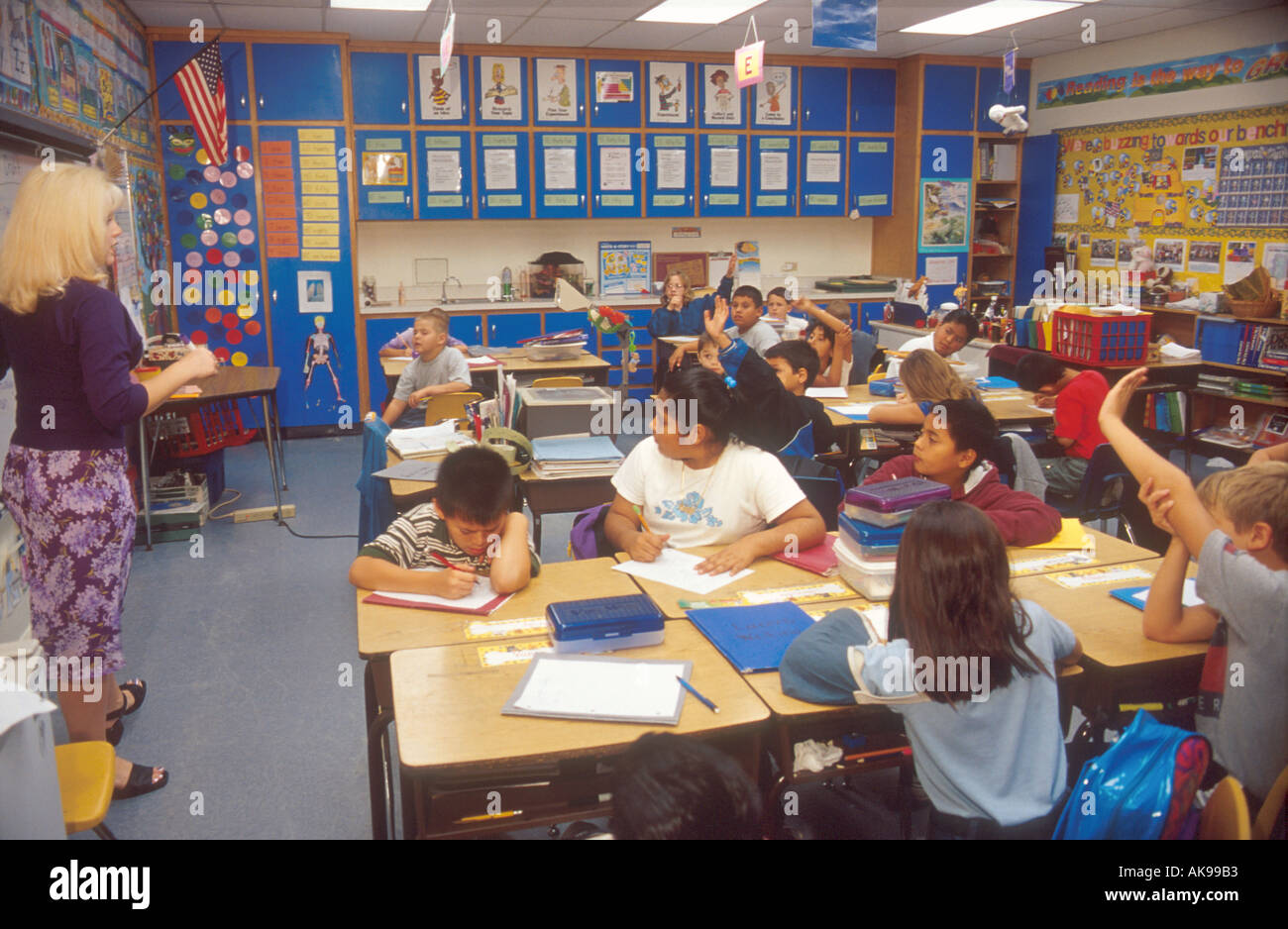 Teacher standing in front of her multi ethnic elementary school class ...