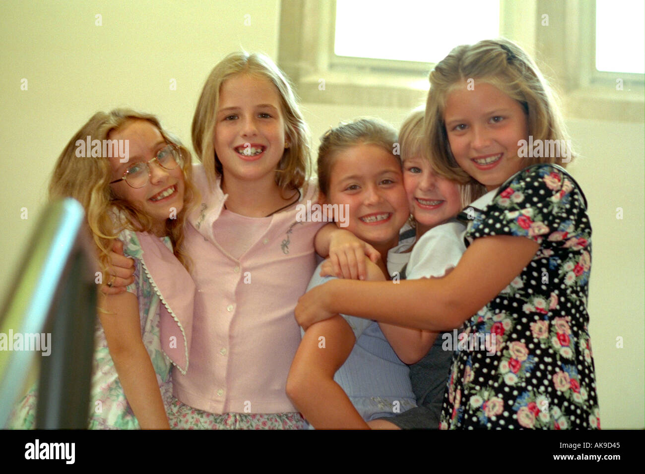 Girl friends age 9 thru 11 embracing after Sunday school. Western ...