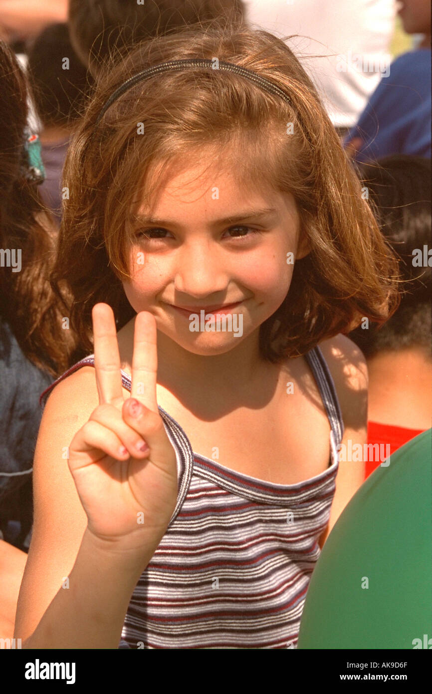 Happy girl age 9 flipping the peace sign at Cinco de Mayo Festival. St ...