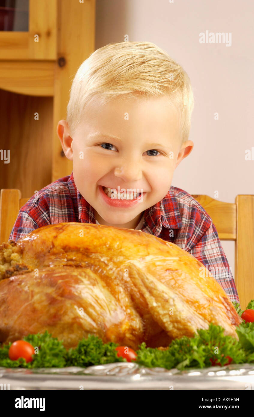 Boy with roast turkey at table Stock Photo - Alamy