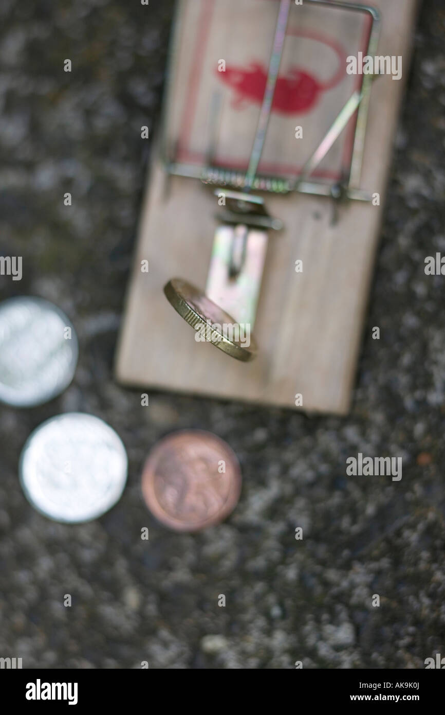 a gold coin in a mousetrap Stock Photo - Alamy