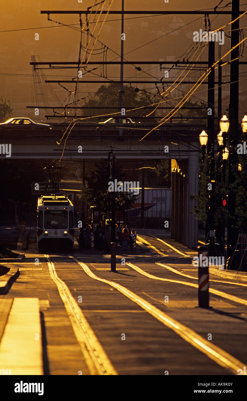 Retro image of Light Rail passengers boarding train at sunset downtown ...