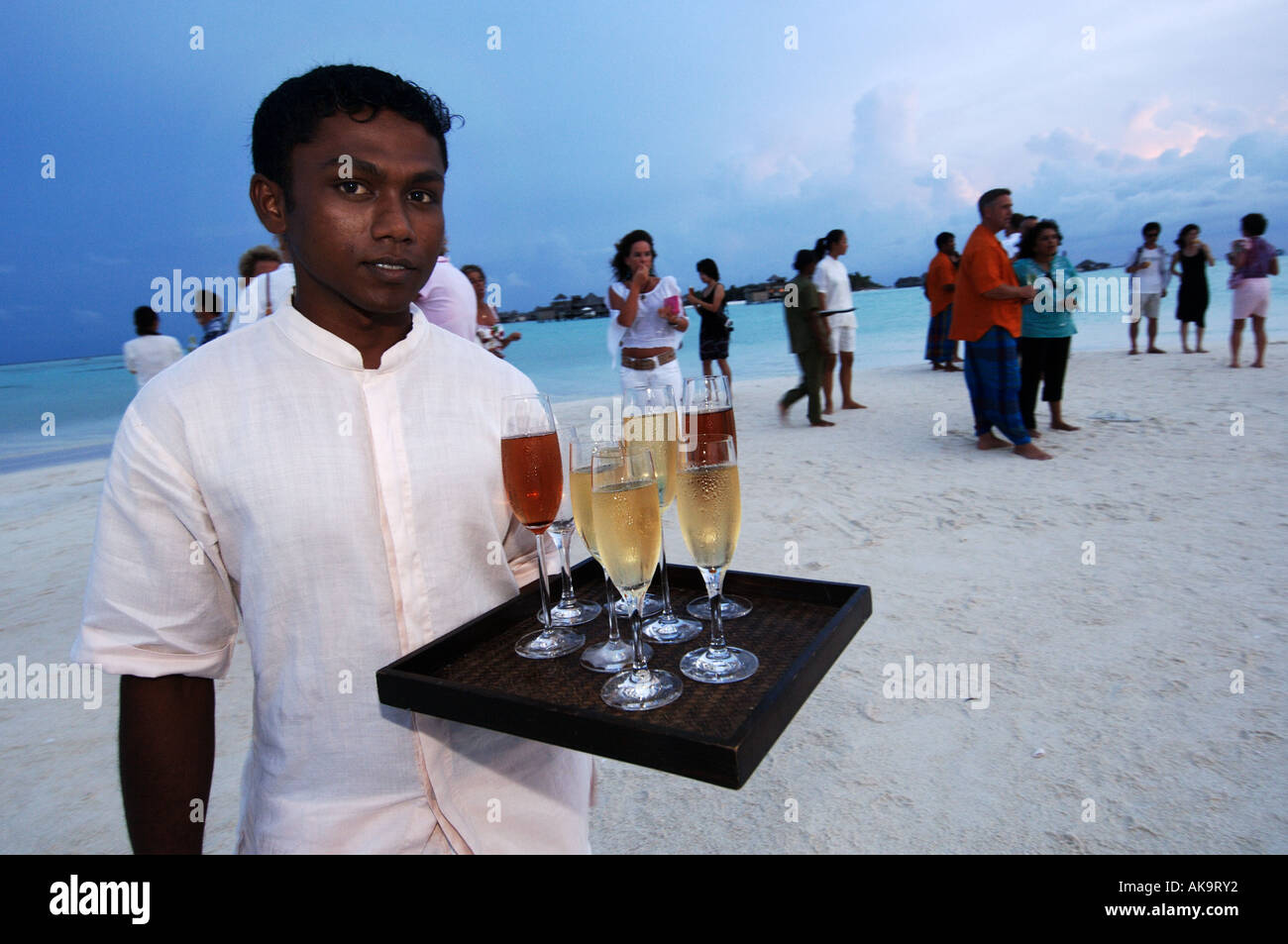 Maldives waiter of the Sonevagili resort serving guest at a beach party ...
