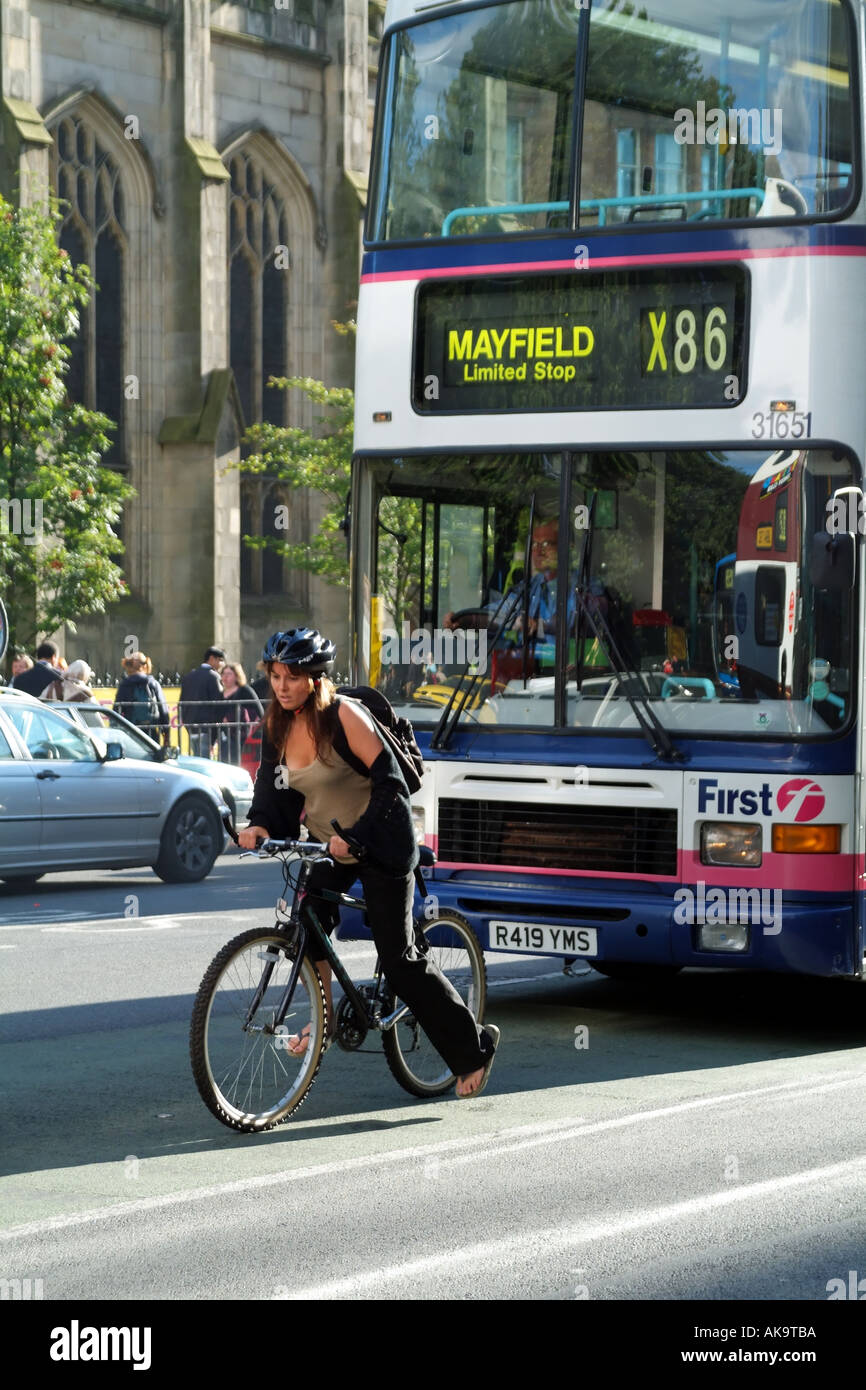 Rush hour young woman cyclist cycling along busy Princes Street ...