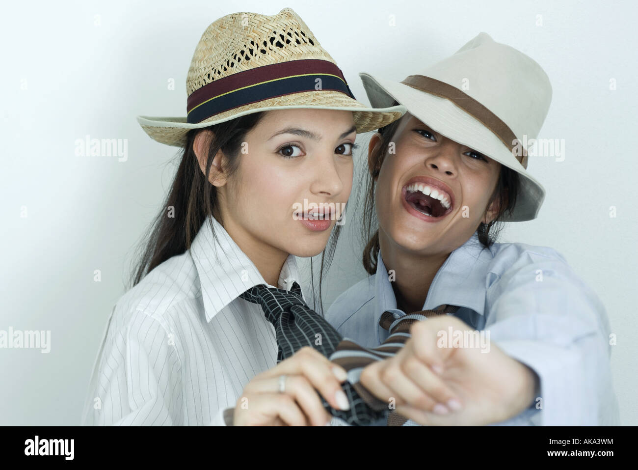 Young woman pulling friends hat hi-res stock photography and images - Alamy