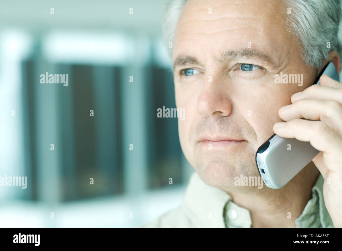 Mature man using cell phone, looking away, portrait Stock Photo - Alamy