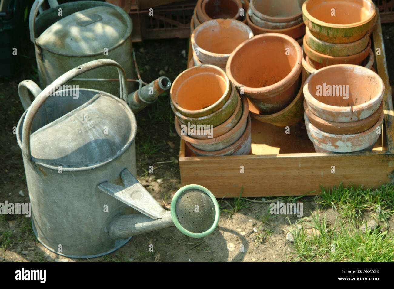 watering cans and stacked old terracotta pots Stock Photo - Alamy