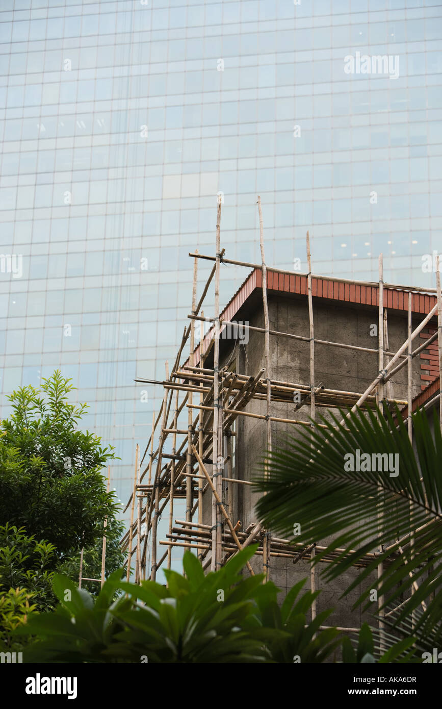 Bamboo scaffolding around building, glass facade of skyscraper in background Stock Photo - Alamy