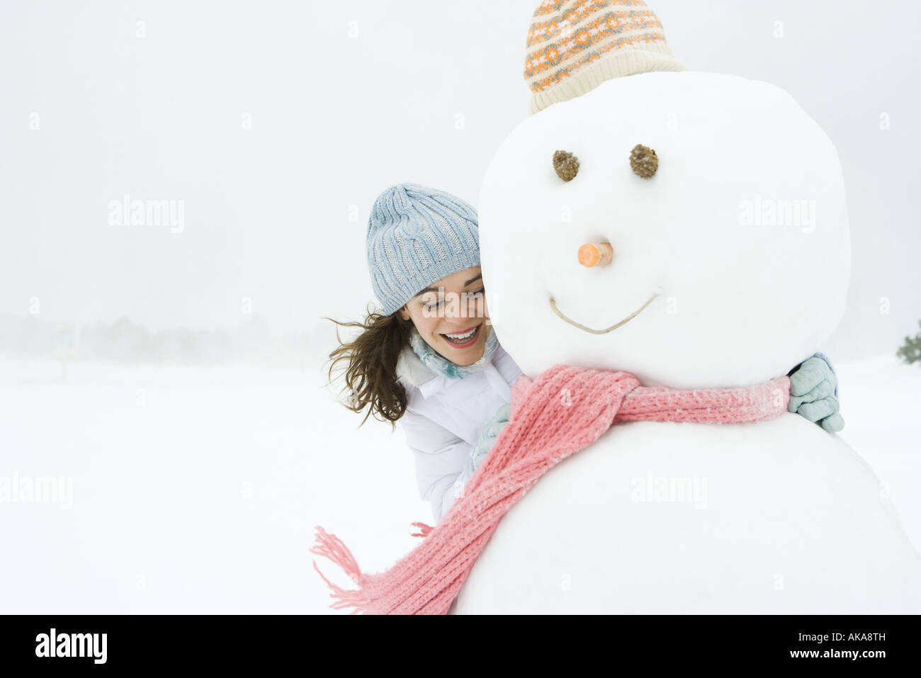 Female embracing snowman, smiling, looking down portrait Stock Photo ...