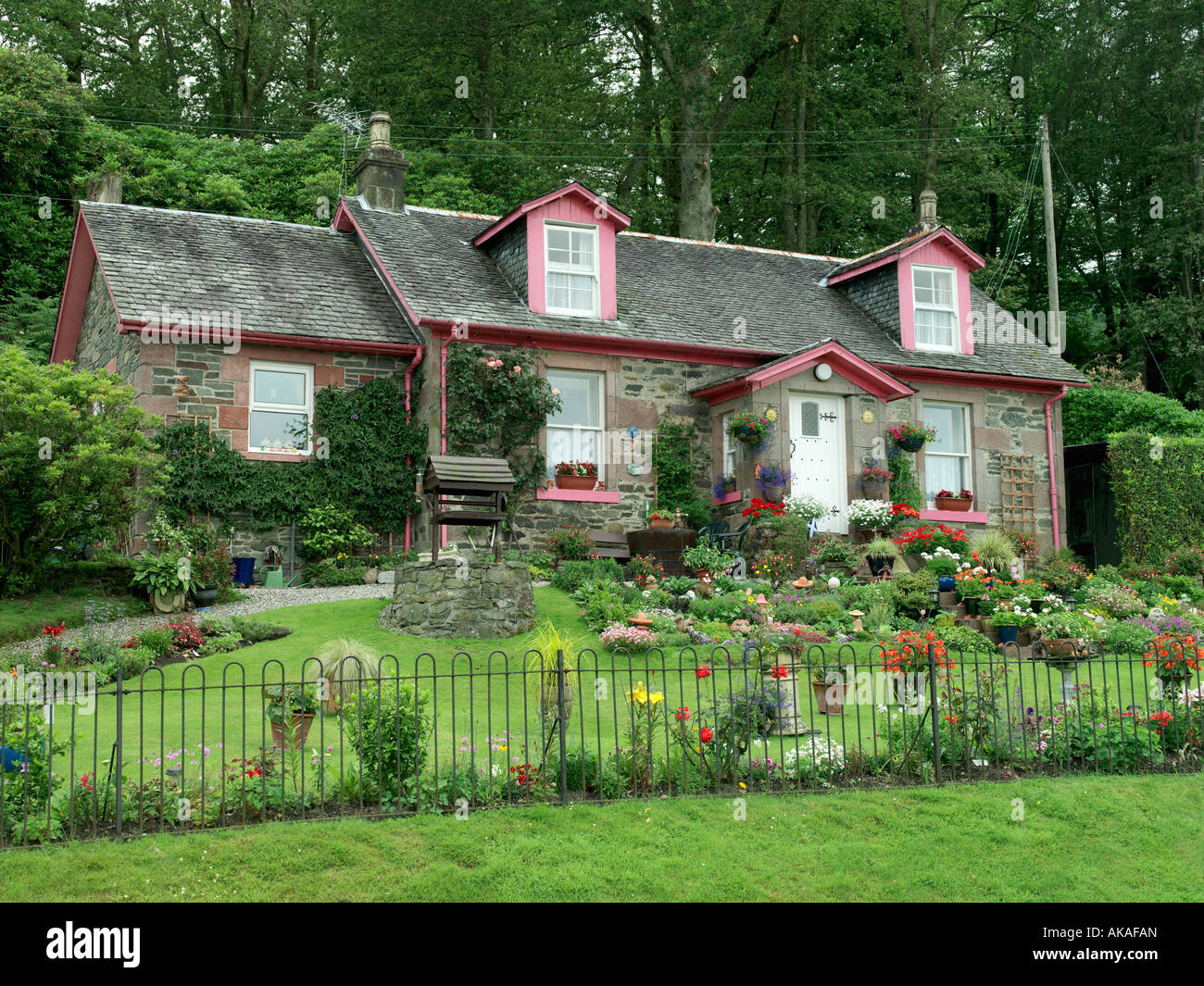 Stone country cottage with immaculate gardens and a well Stock Photo ...