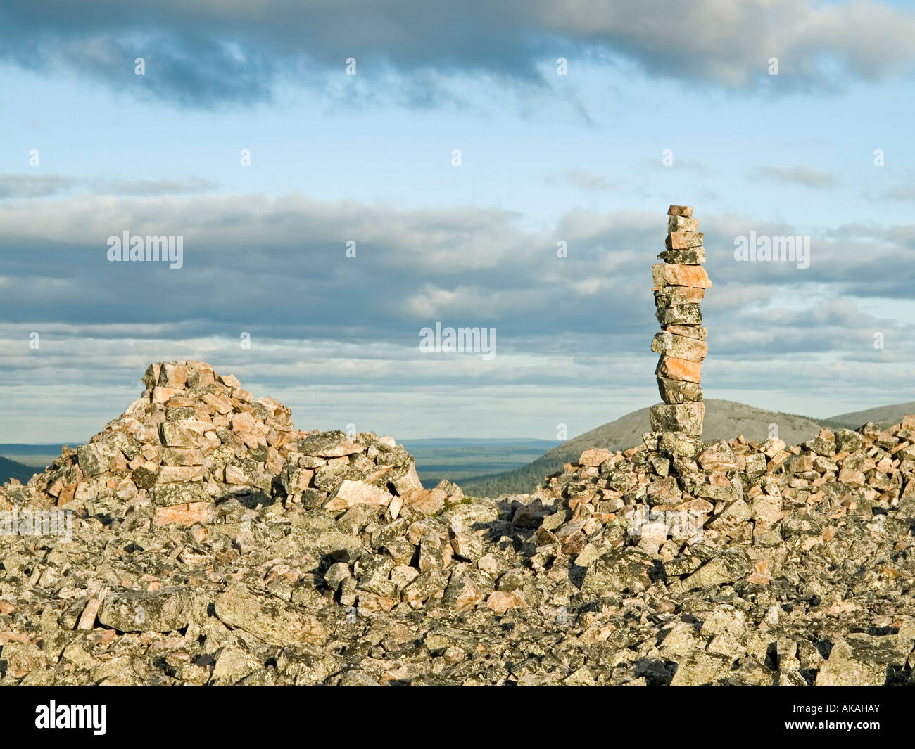 landscape with stones piled into a tower on the top of stony fell ...