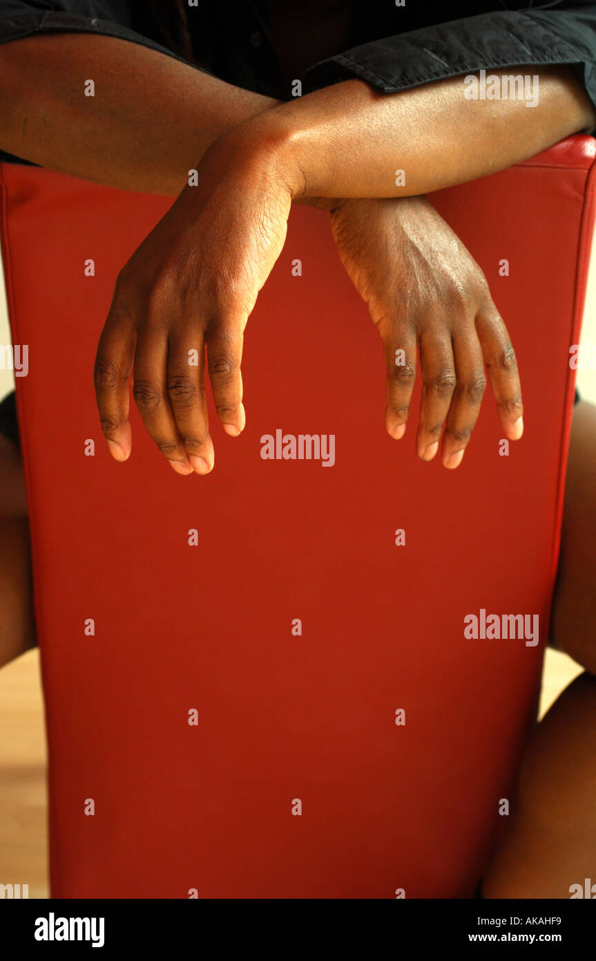 Black Woman with Hands over the back of a red leather chair Stock Photo ...