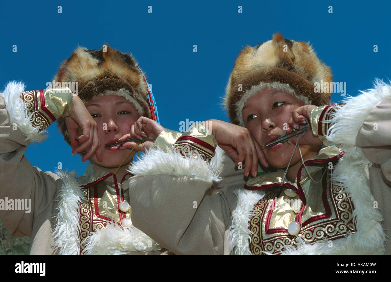 Portrait of young girls playing national Altaic instrument komus. El ...