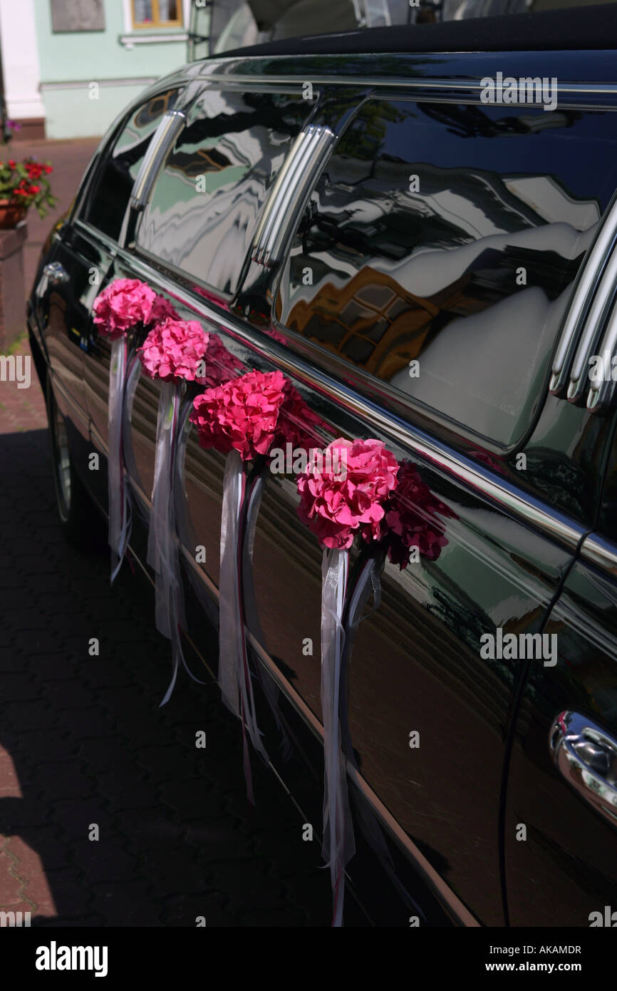 Black weddding car limousine showing decorations of flowers on side ...