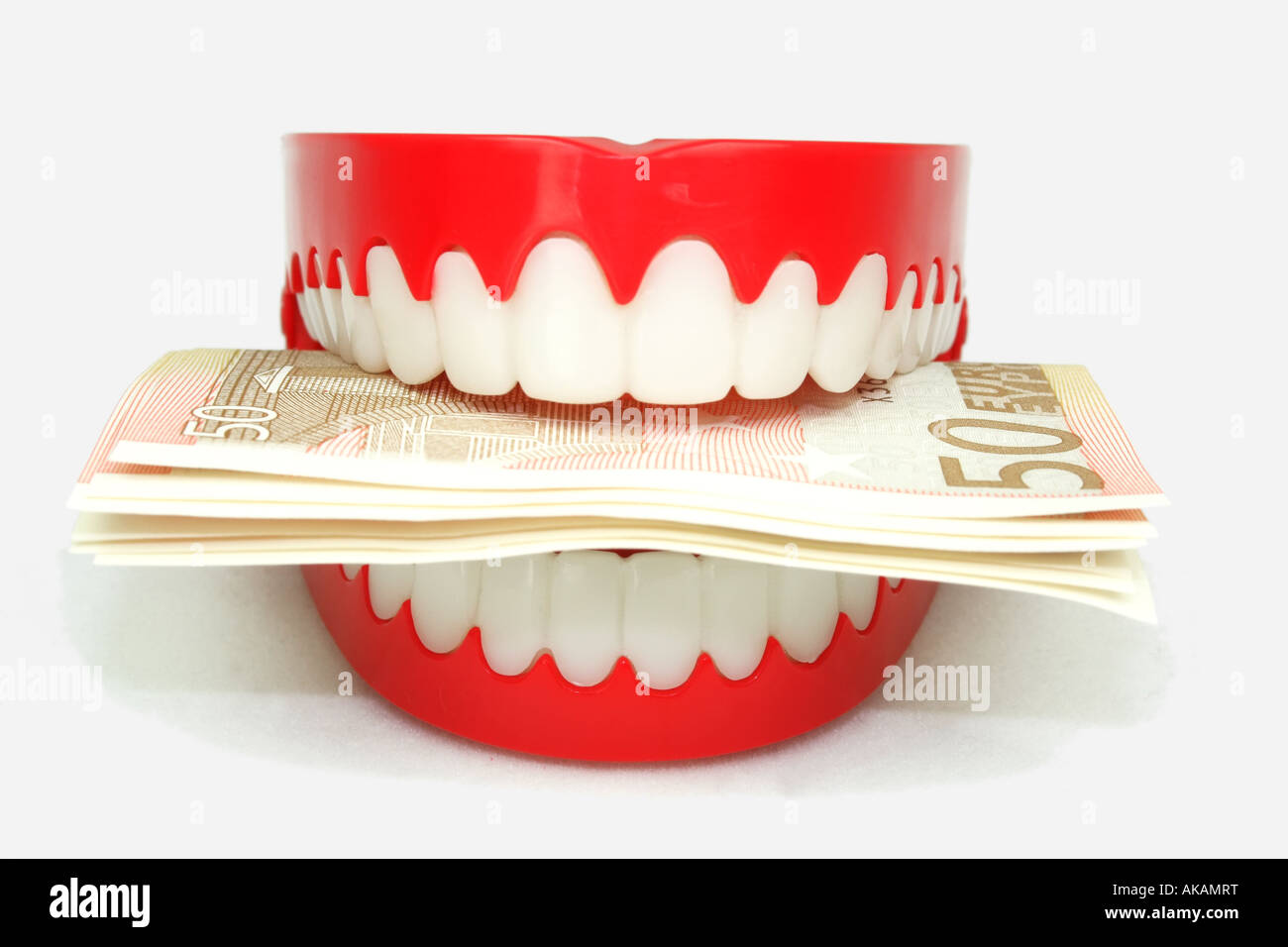 Euro notes held between novelty teeth - "put your money where your ...
