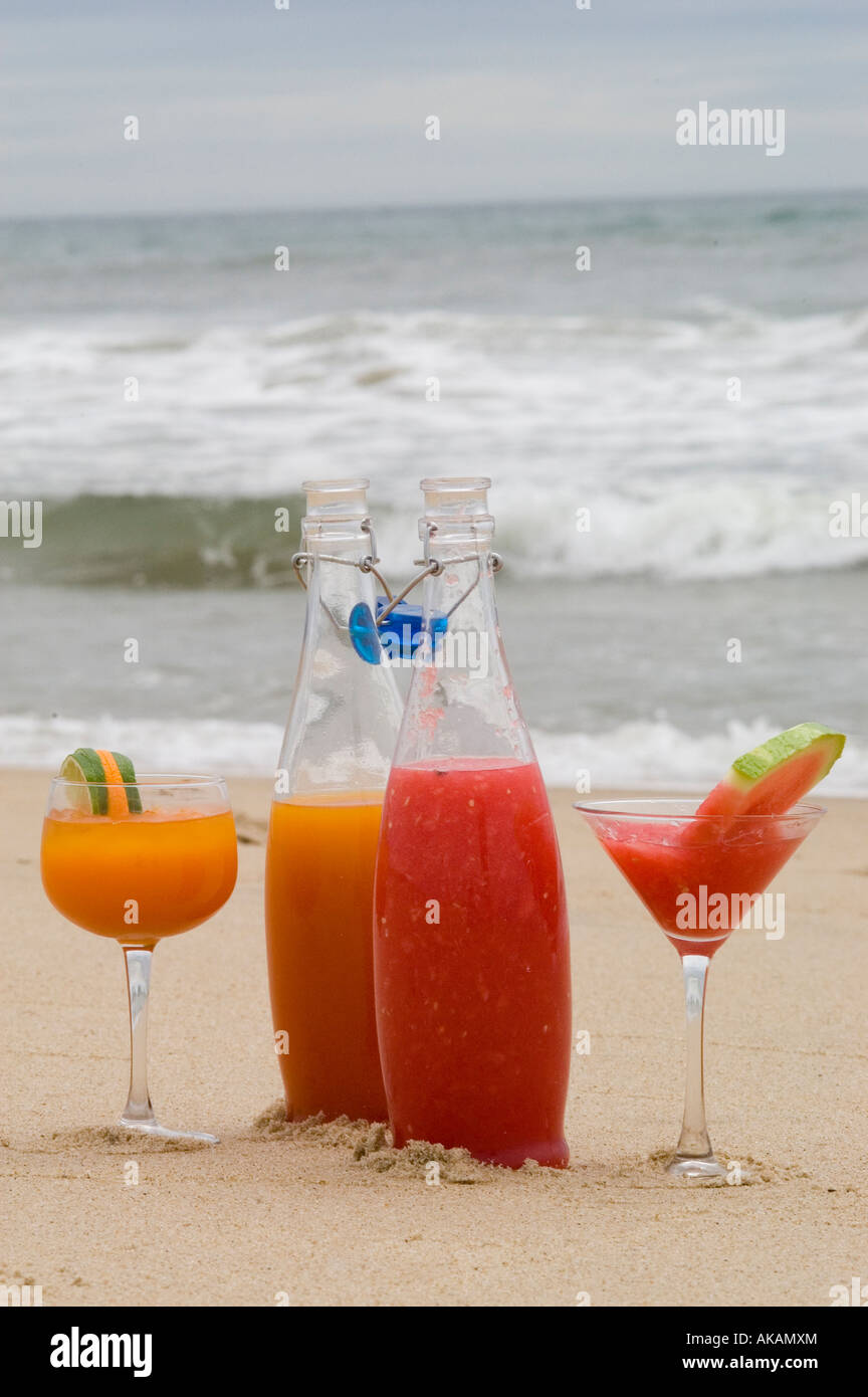 Colorful Cocktails sitting on the beach with ocean surf in the ...