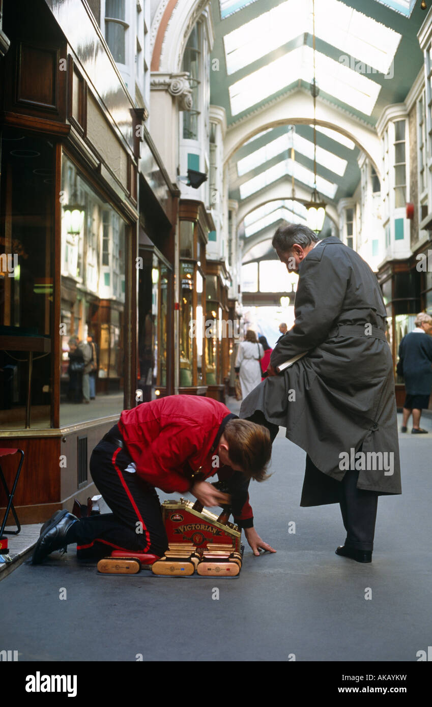 Shoeshine boy polishing business mans shoes Stock Photo - Alamy