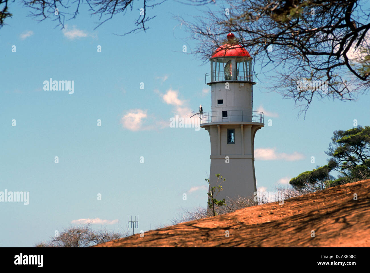 A red roofed lighthouse stands as a beacon against a blue Hawaiian sky ...