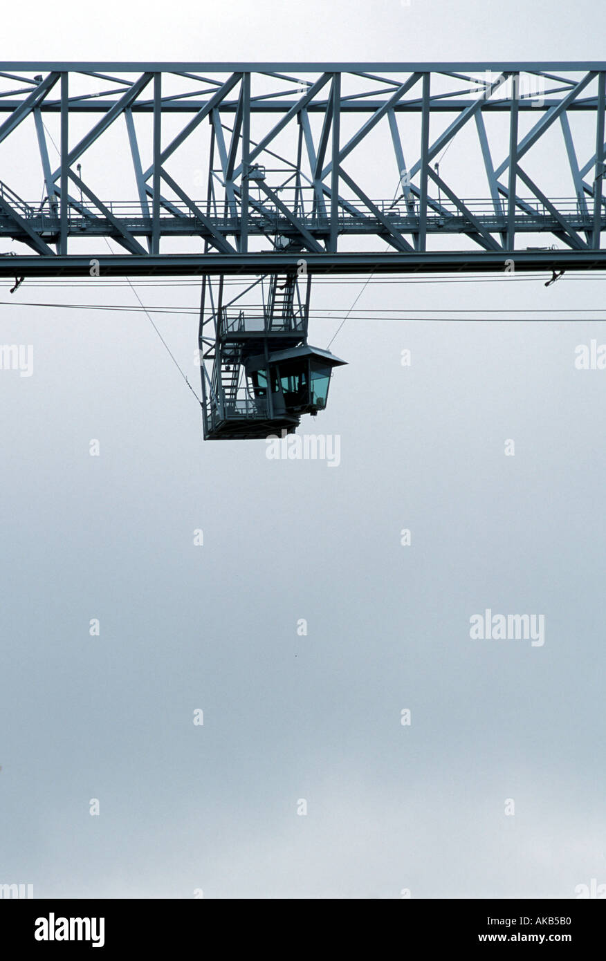 A diminutive construction cage is suspended beneath the massive steel ...
