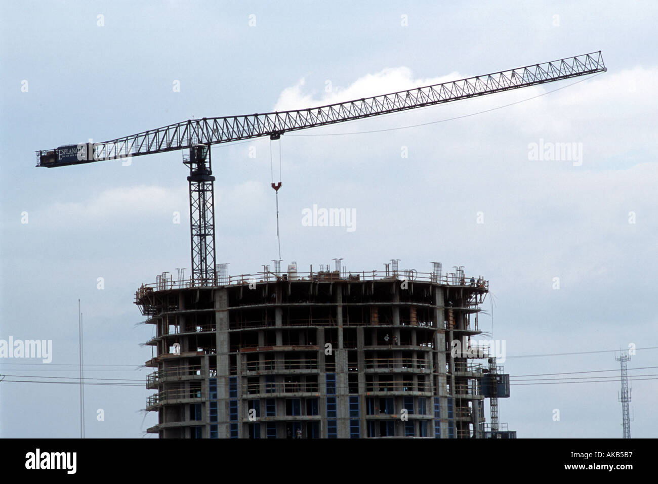 A massive construction tower crane balances and hoists building ...