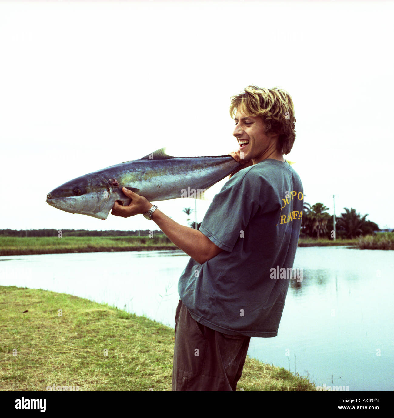 Young man with a large king fish, Queensland Australia Stock Photo - Alamy