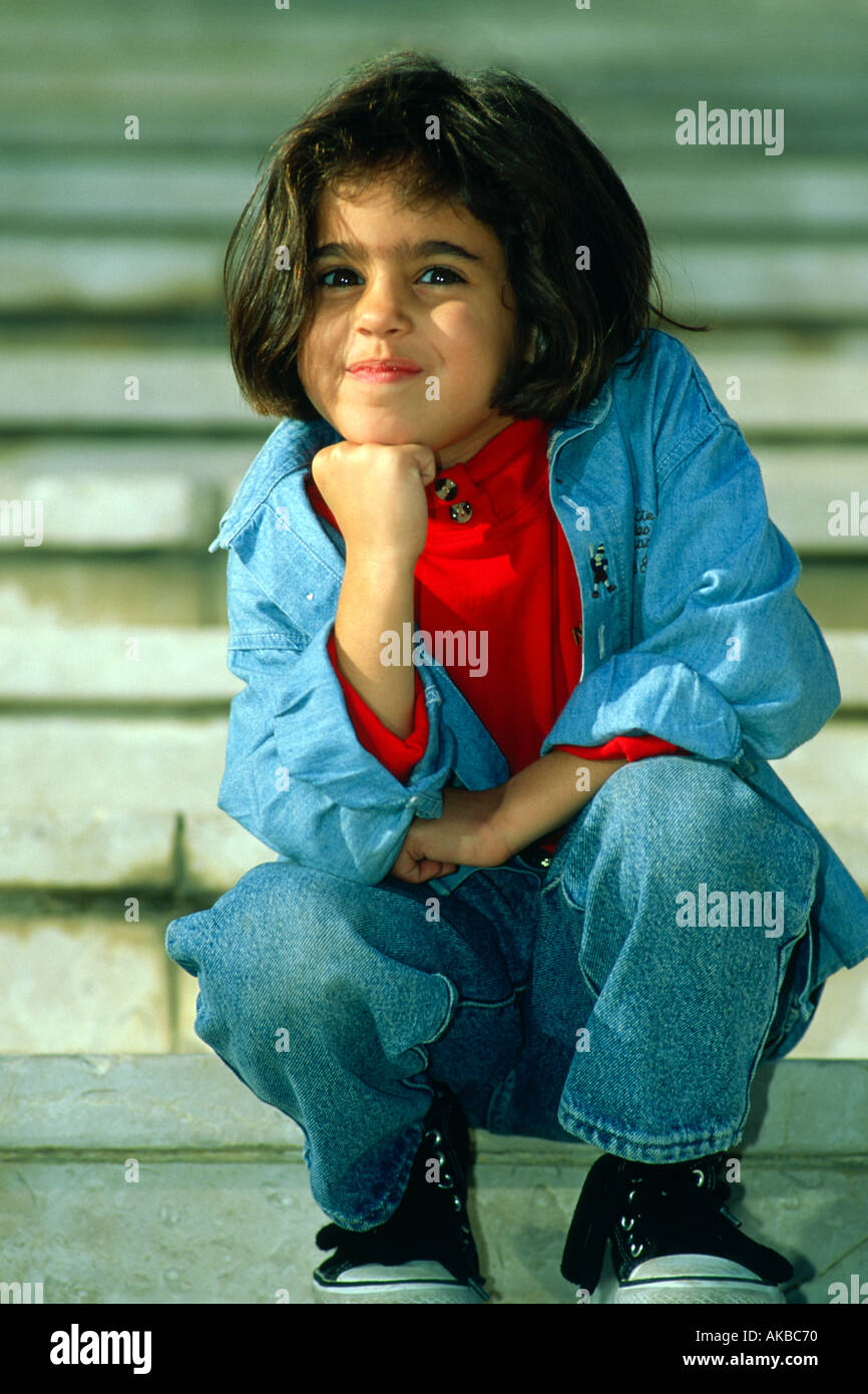 Little girl seating on steps facing camera Stock Photo - Alamy